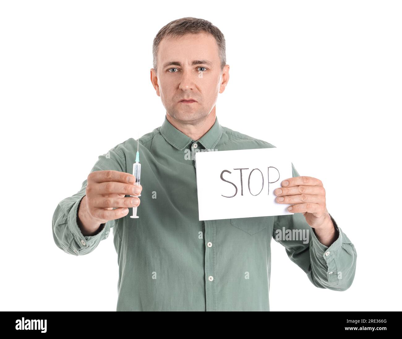 Mature drug addict holding paper with word STOP and syringe on white ...