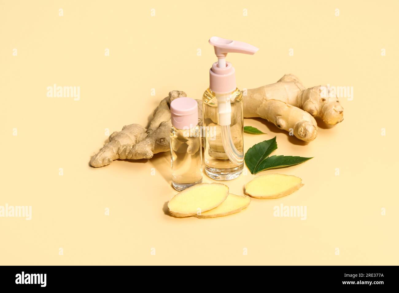 Bottles of ginger cosmetic oil and leaves on yellow background Stock ...
