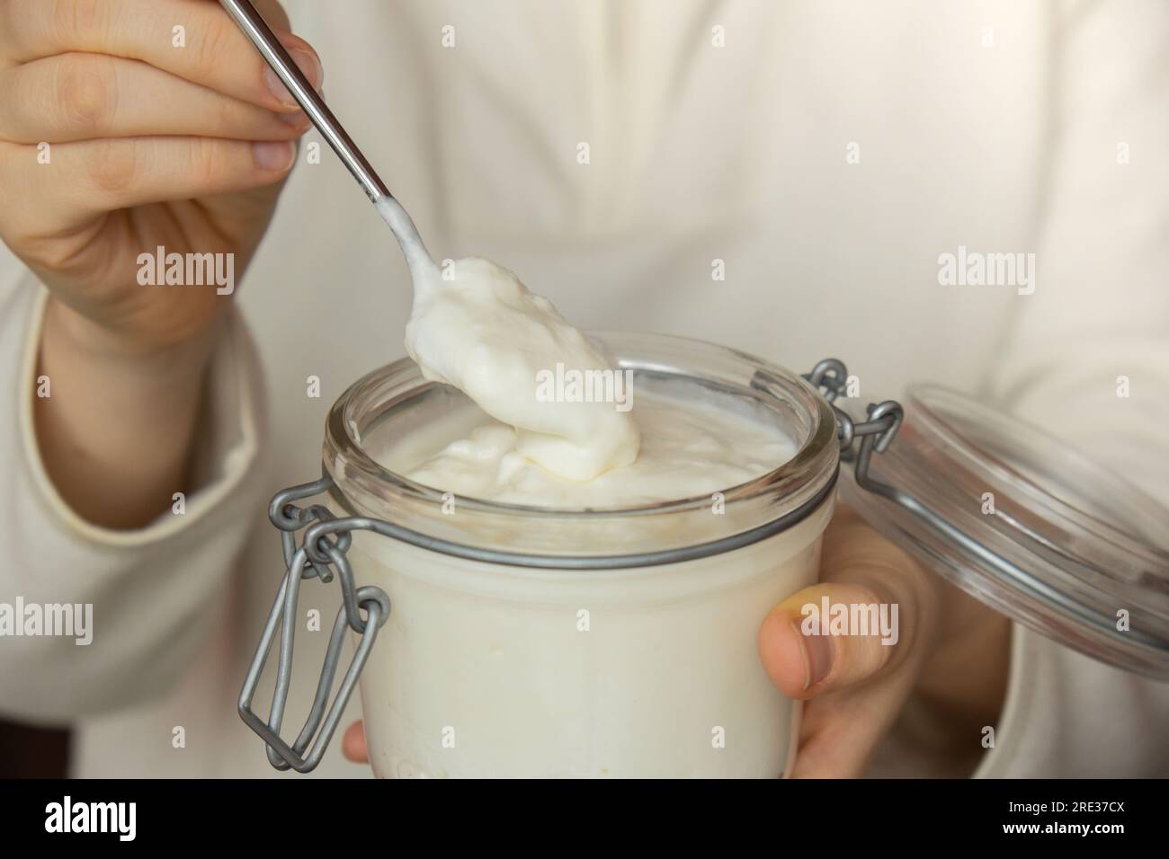 Unrecognizable woman eating from Glass jar natural organic homemade ...