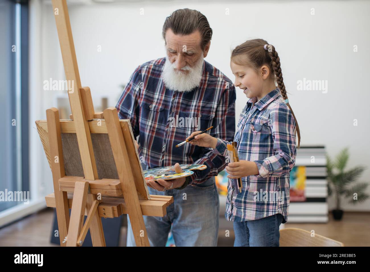 Close up view of senior grandfather and little child in similar outfits ...
