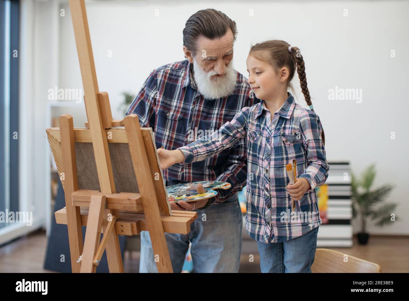 Close up view of senior grandfather and little child in similar outfits ...