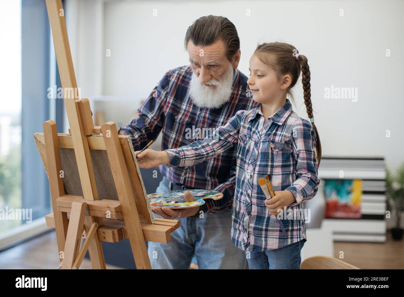 Close up view of senior grandfather and little child in similar outfits ...