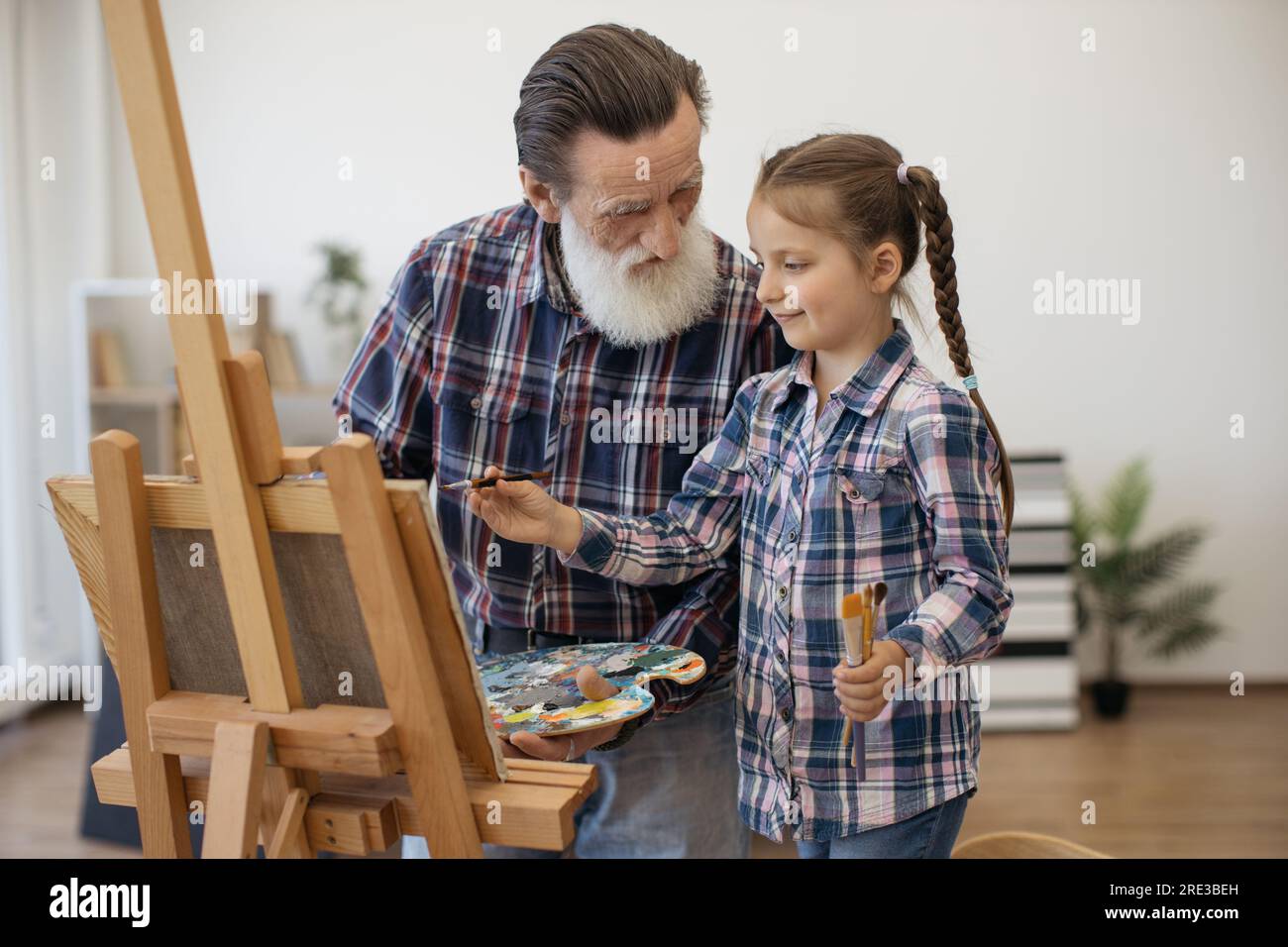 Close up view of senior grandfather and little child in similar outfits ...