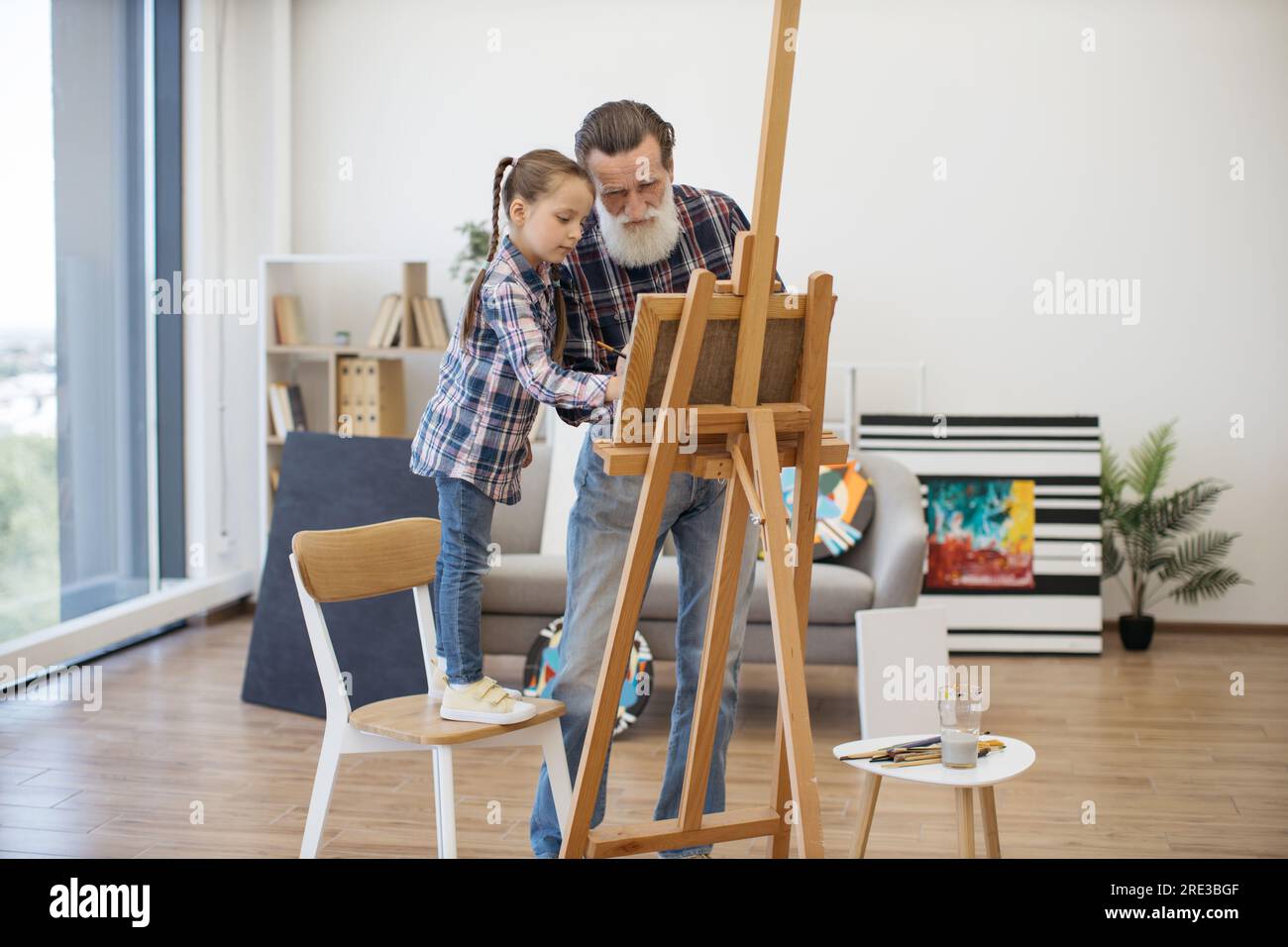 Close up view of senior grandfather and little child in similar outfits ...