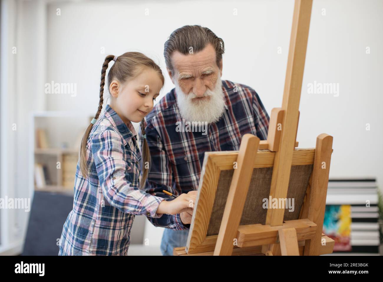 Close up view of senior grandfather and little child in similar outfits ...
