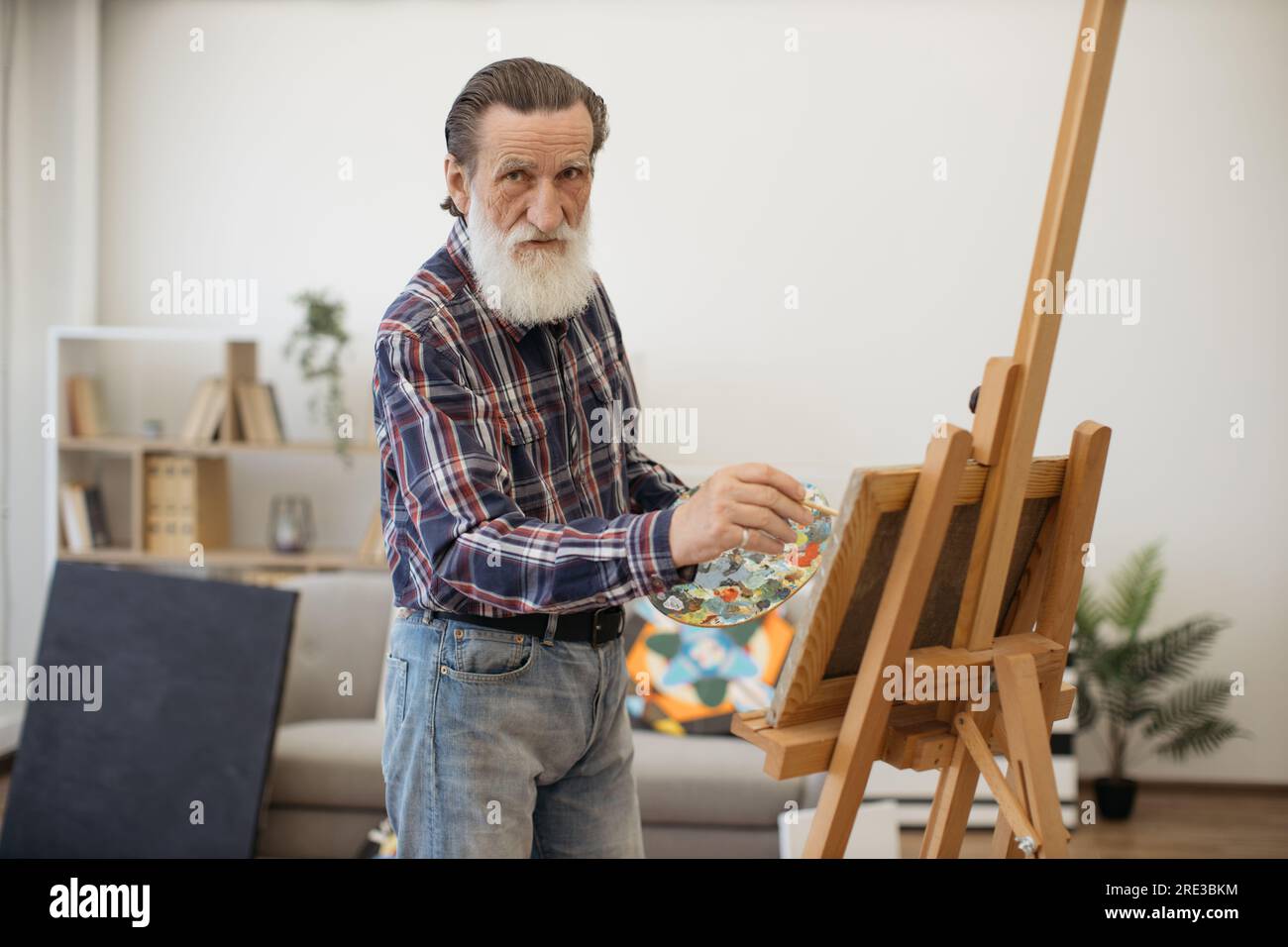 Portrait of confident bearded pensioner with brush posing for camera ...