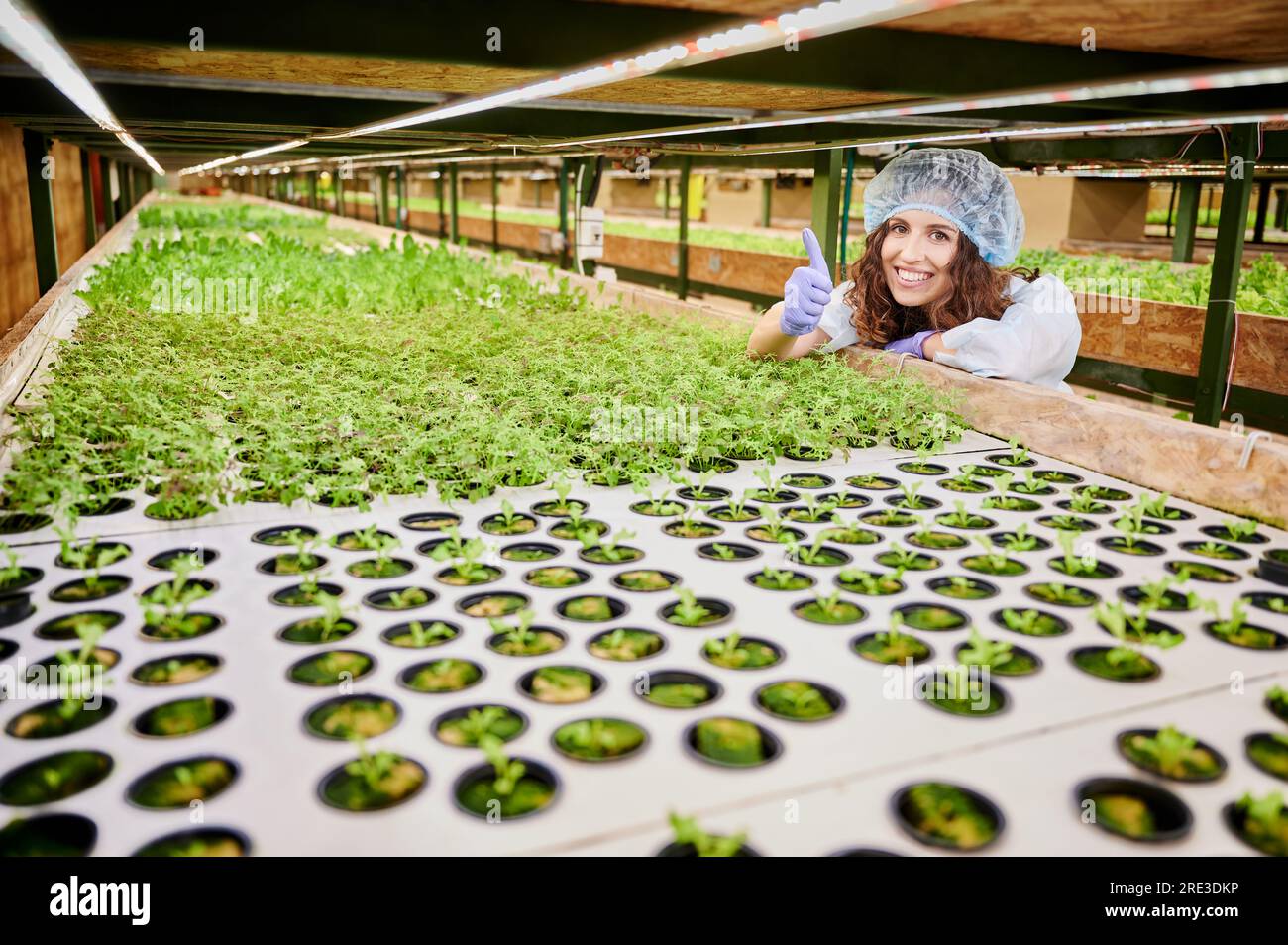 Joyful female gardener showing approval gesture and smiling while ...
