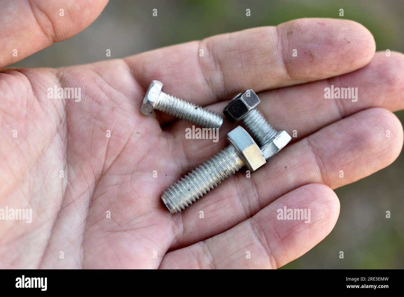 Iron shiny bolts dirty in the palm of your hand. industrial, metallic ...