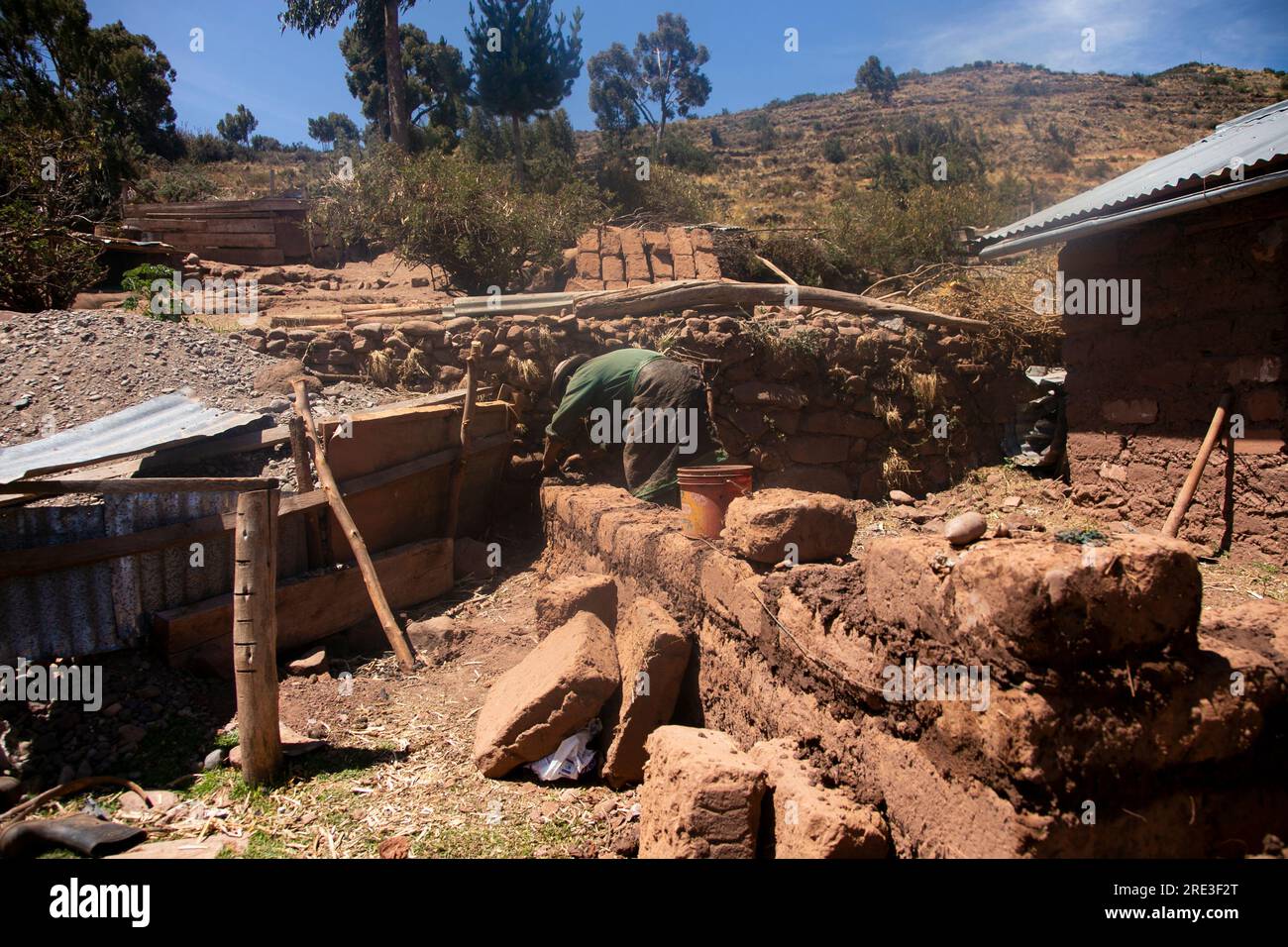 Man building with his hands an adobe house with adobe bricks and mud ...