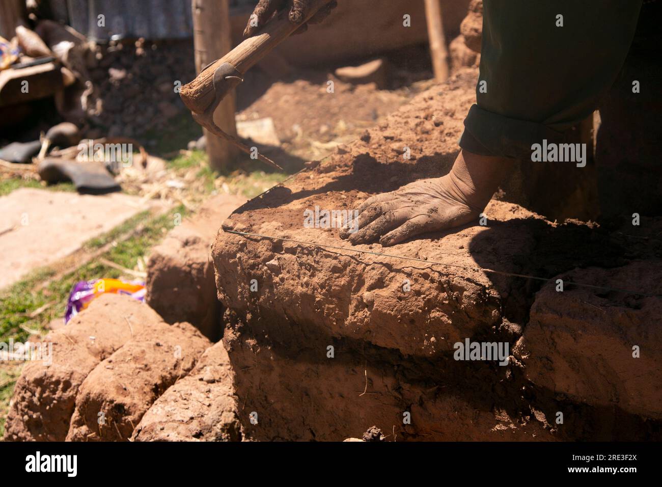 Man building with his hands an adobe house with adobe bricks and mud ...