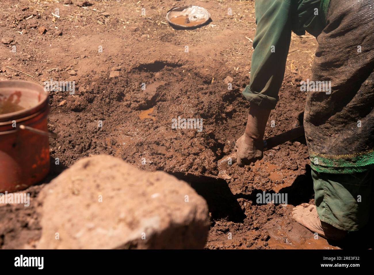 Man building with his hands an adobe house with adobe bricks and mud ...