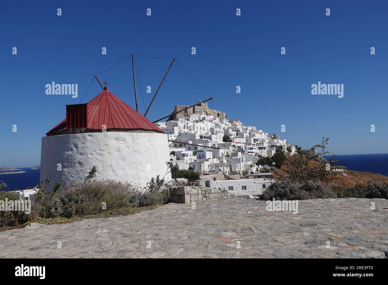 View a Greek windmill with a backdrop of the main Chora in Astypalaia ...