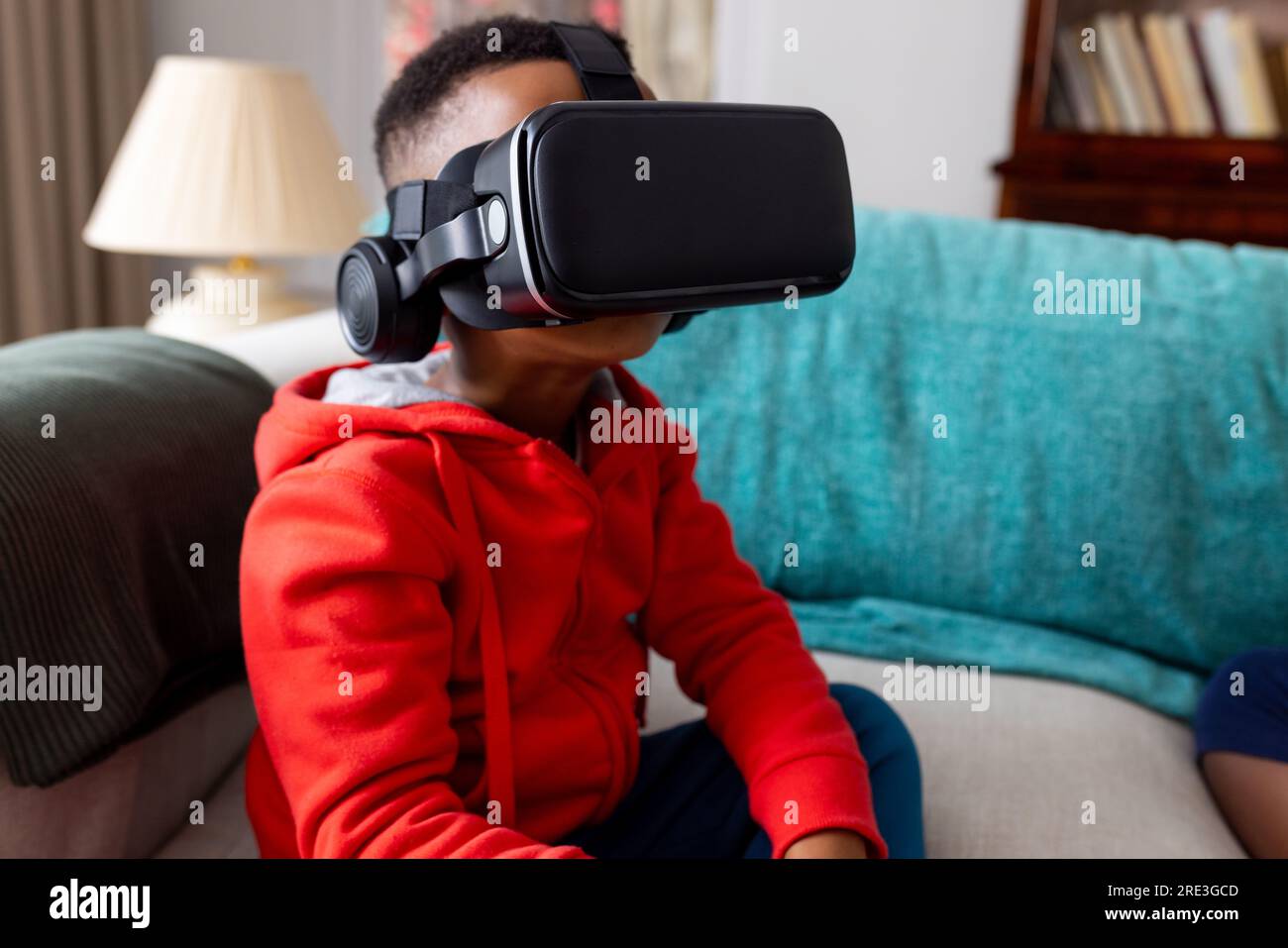 Happy african american boy using vr headset on sofa at home Stock Photo ...