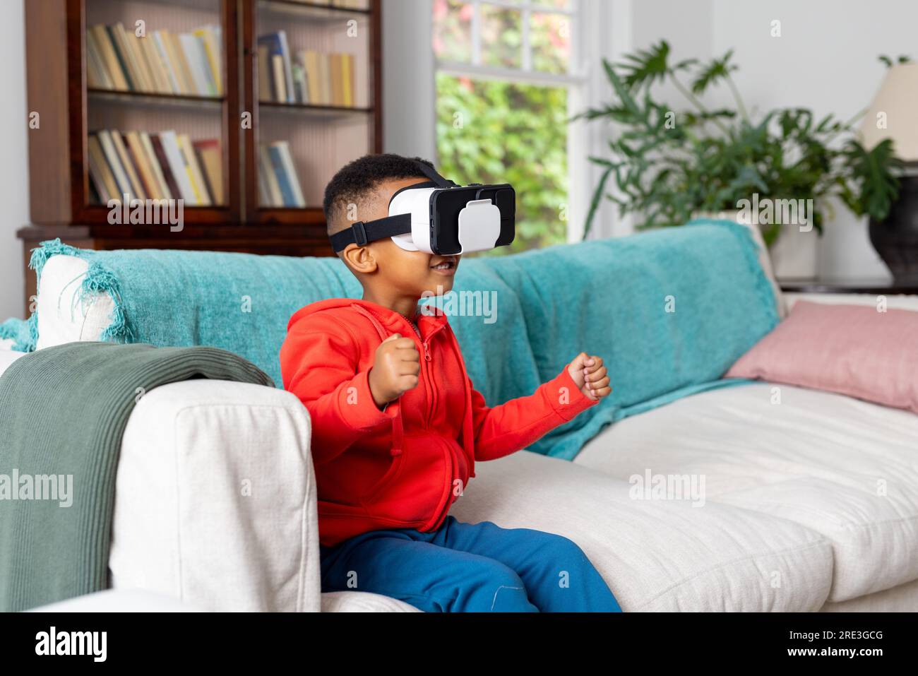 Happy african american boy using vr headset on sofa at home Stock Photo ...