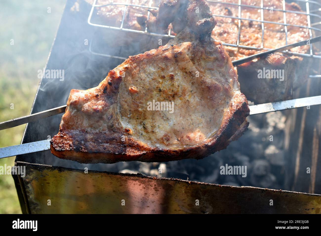 Frying pork loin on a barbecue grid. Delicious pieces of pork loin with ...
