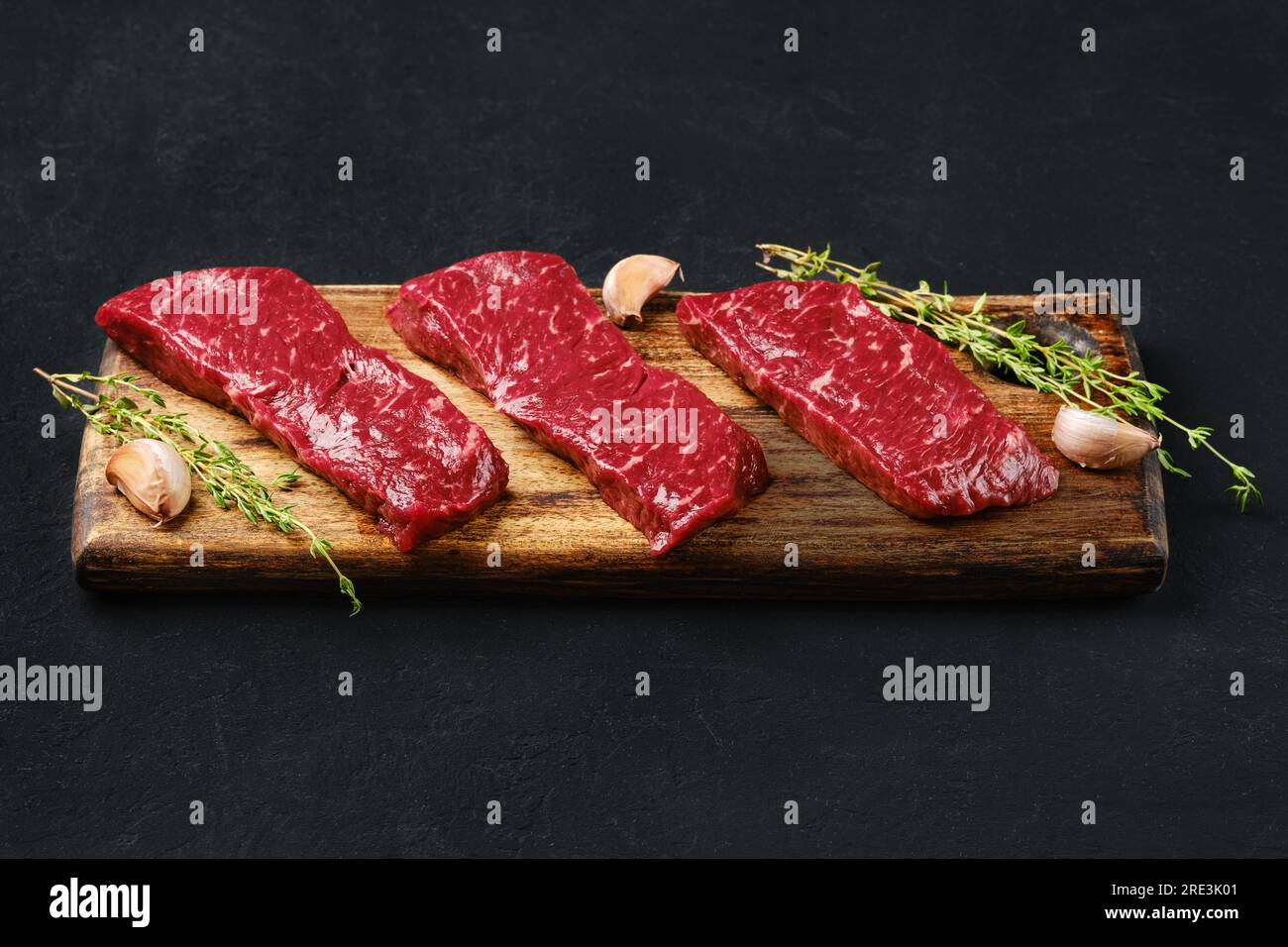 Raw strip steak boneless on wooden cutting board Stock Photo - Alamy