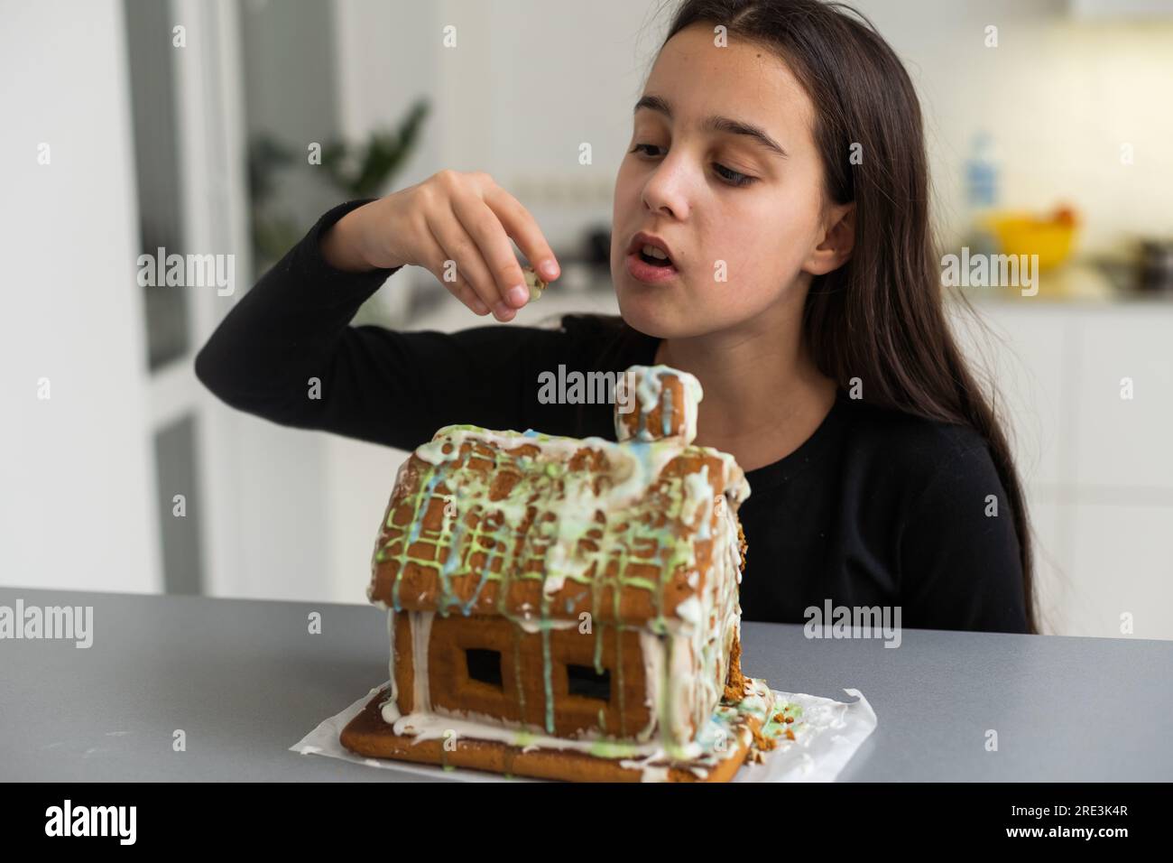 A teenage girl is eating a gingerbread house Stock Photo - Alamy