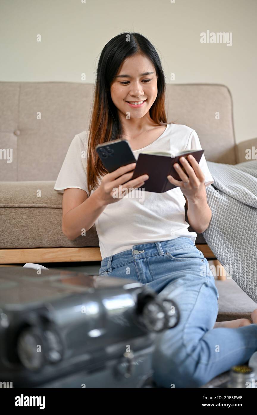 A portrait of a beautiful and happy young Asian woman checks her ...