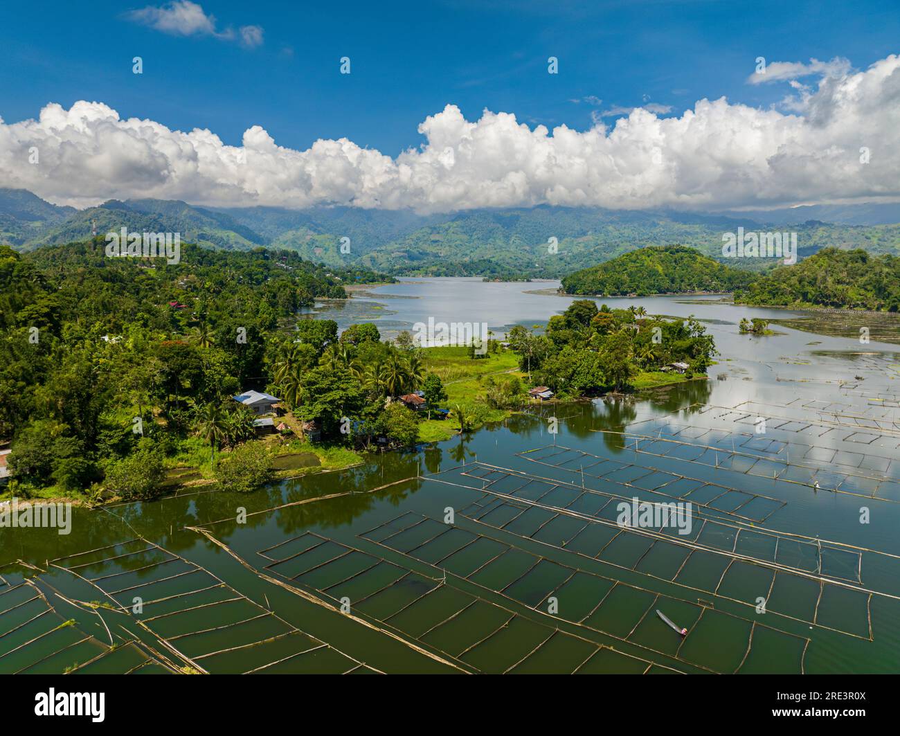 Moving forward over the fish farm in Lake Sebu under blue sky and ...