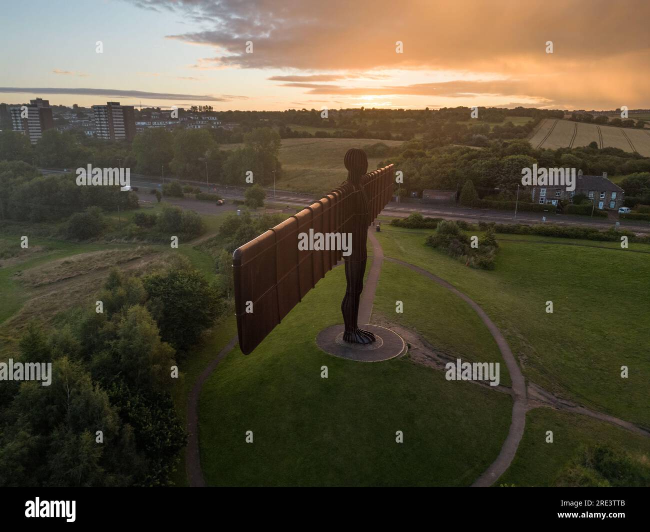 Side on drone shot of Angel of the North with sun rising on the wind ...