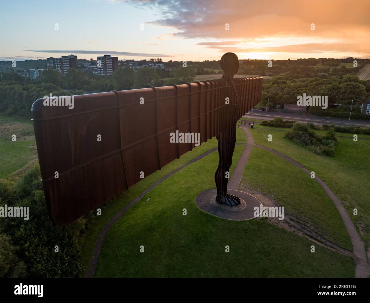Side on drone shot of Angel of the North with sun rising on the wind ...