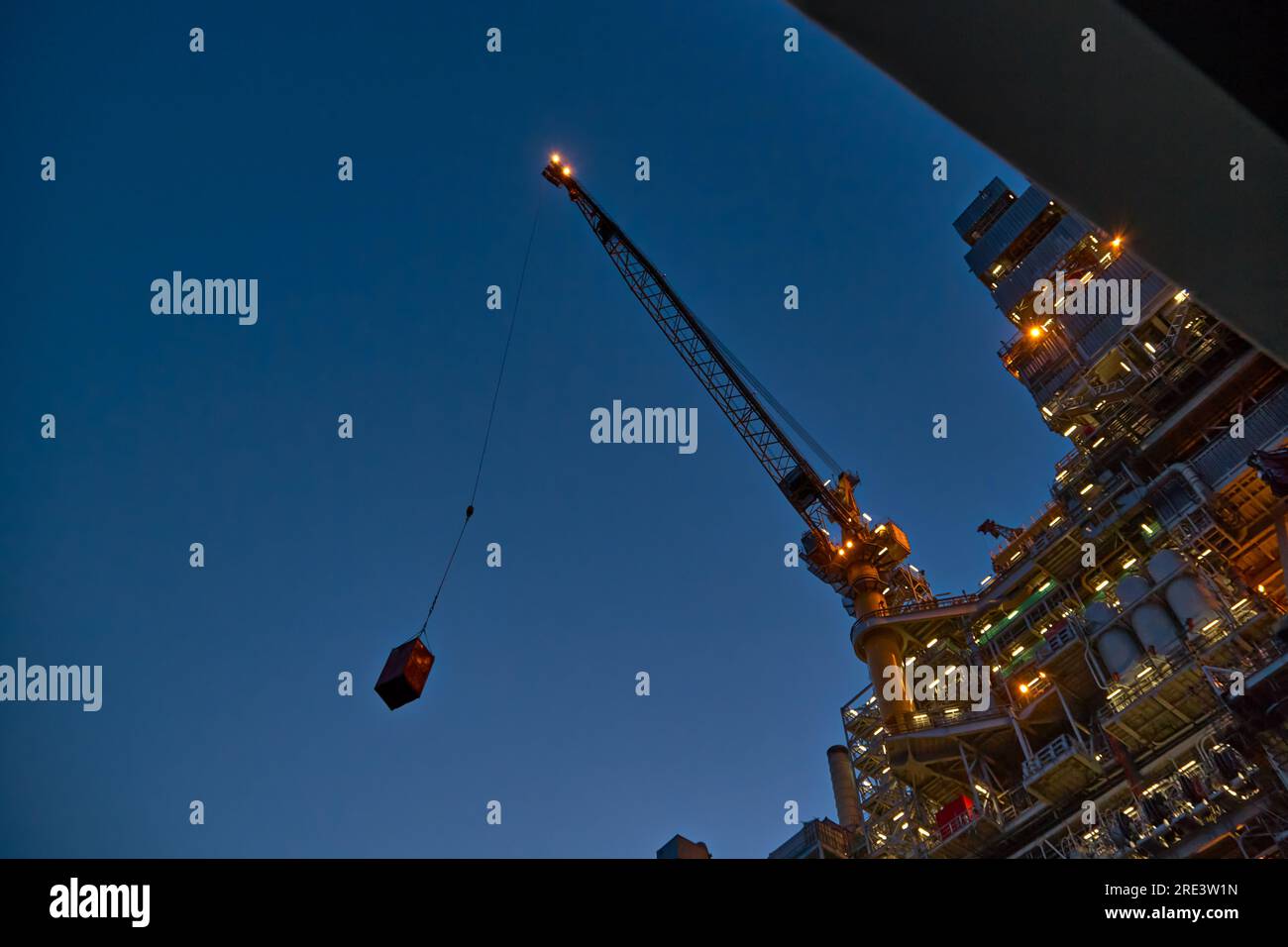 Jack up rig crane lifts container during cargo operations in the sea ...