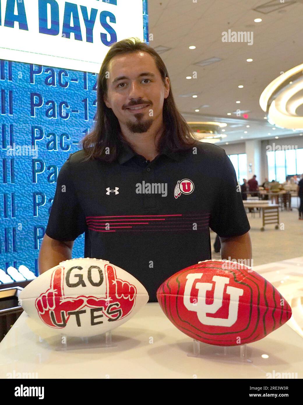 Utah quarterback Cameron Rising poses in front of two painted footballs ...