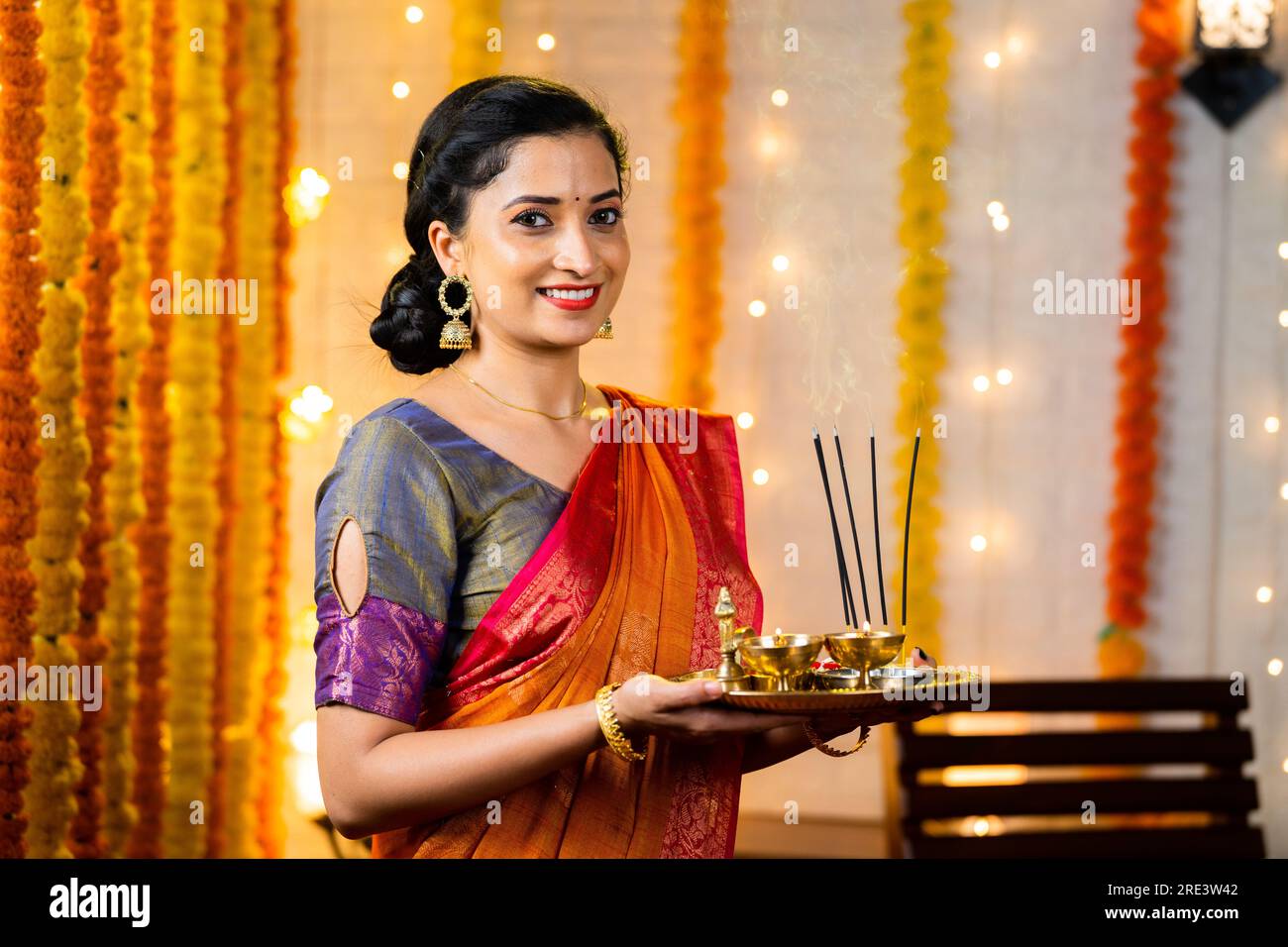 Happy indian girl in traditional ethnic wear holding pooja plate with ...