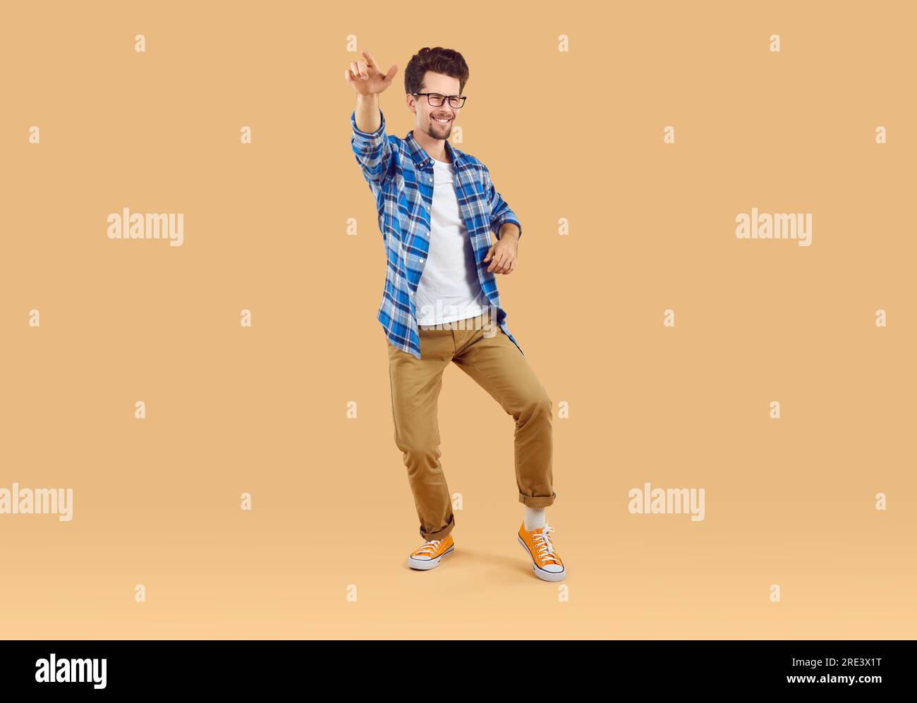 Happy, funny, cheerful student in casual clothes dancing on beige ...