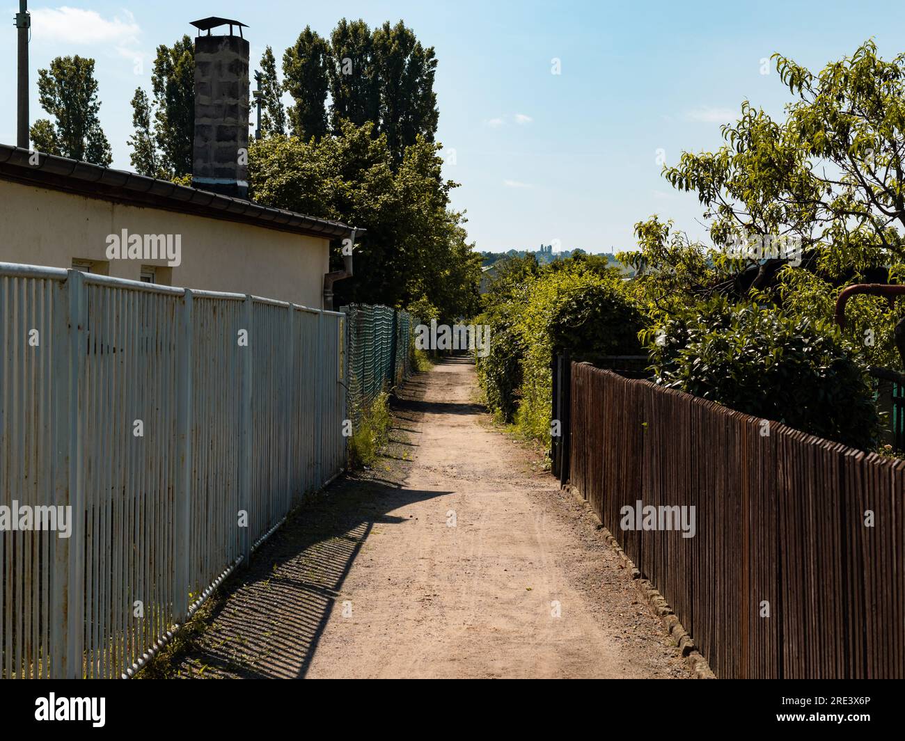 Path in an German allotment gardeners association with fences on the ...