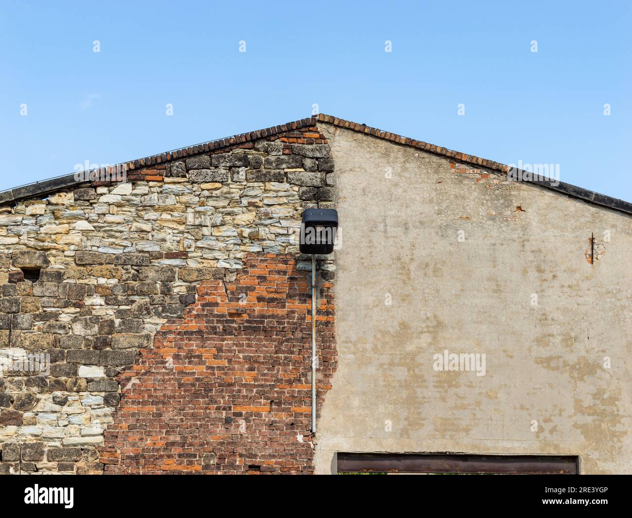 Old facade with a broken wall plaster and a retro lamp. Different types ...