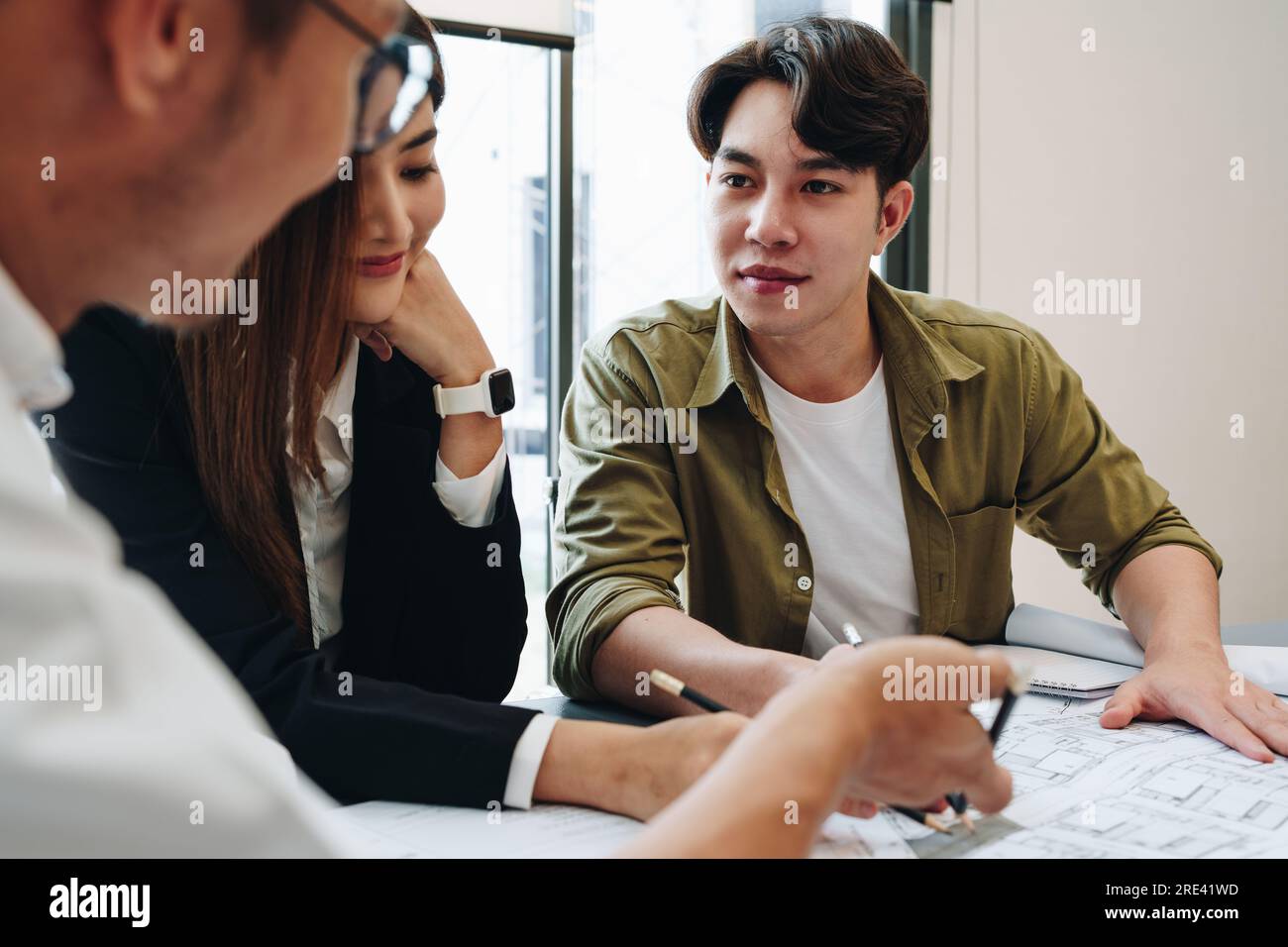 multi ethnic engineer brainstorming and measuring for cost estimating ...