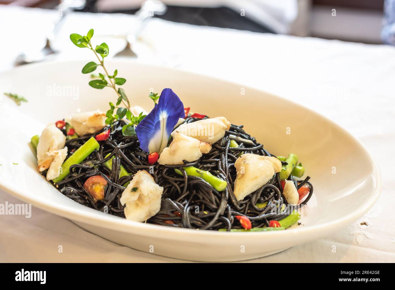 Squid-ink spaghetti with blue swimer crab Stock Photo - Alamy