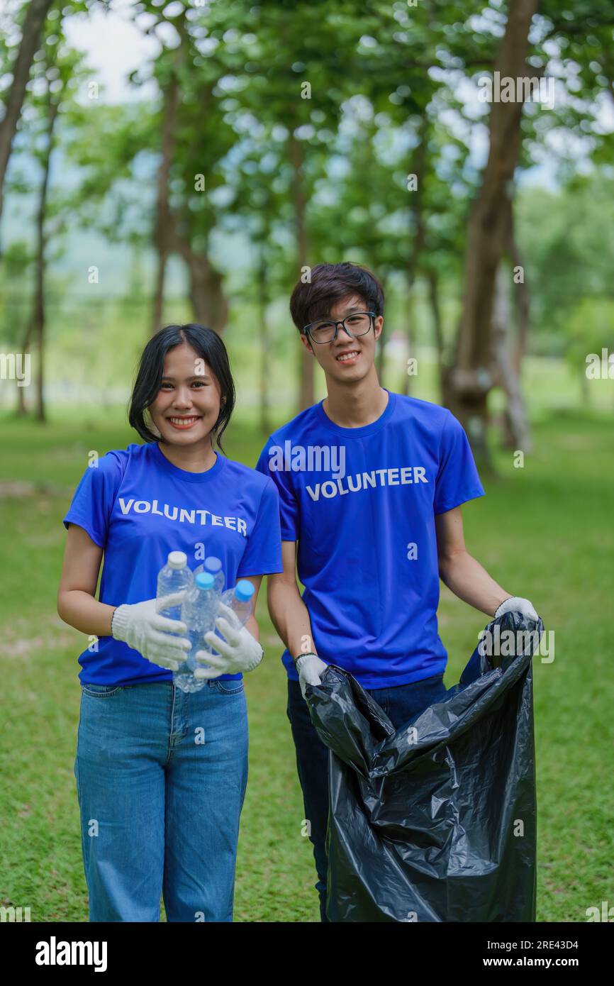 Multiethnic volunteers donate their time holding black garbage bags to ...