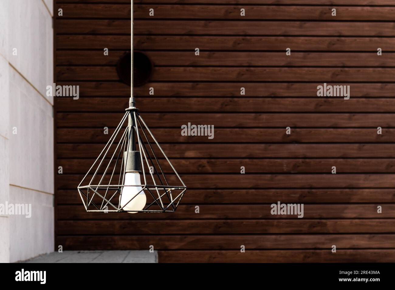 Modern garden pendant lamp hanging on the outdoor terrace during on ...