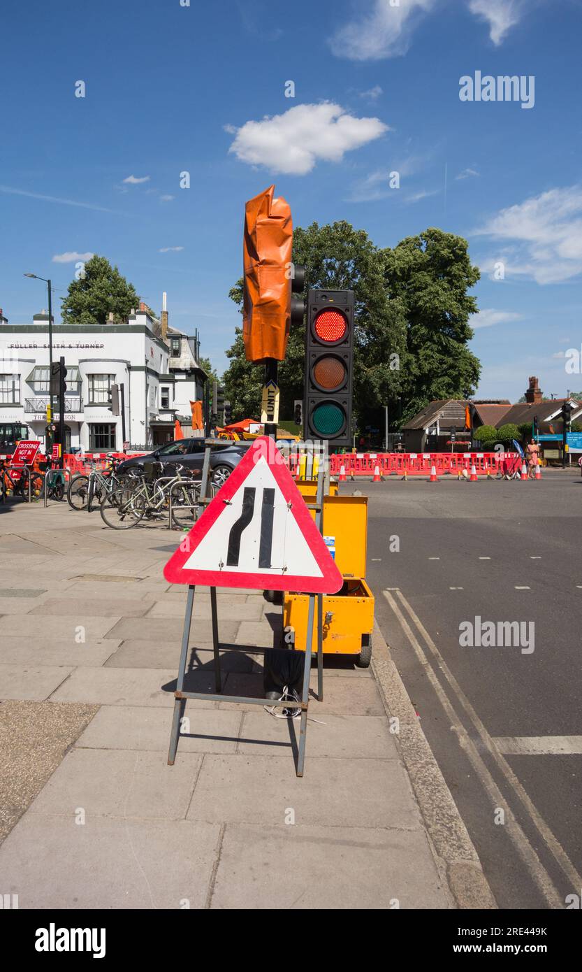Temporary traffic lights and a Road Narrows left Highway Code road sign ...