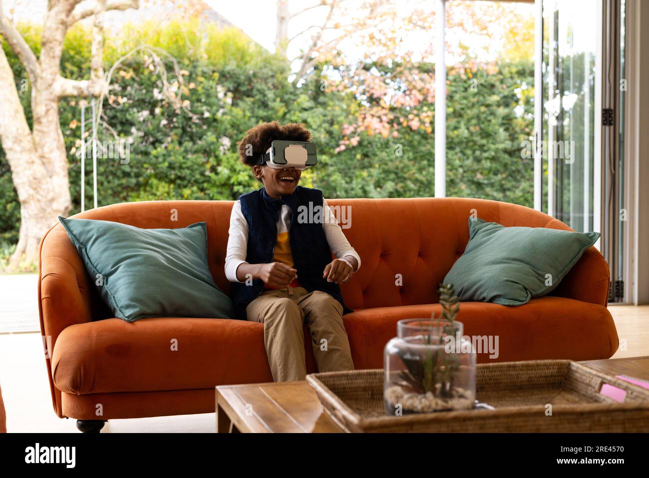 Happy african american boy sitting on sofa and using vr headset Stock ...