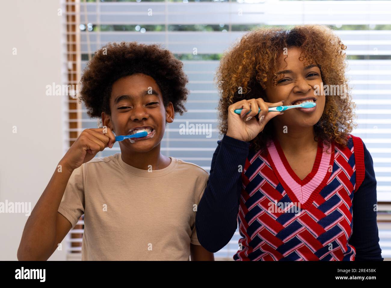 Happy african american mother and son brushing teeth in bathroom Stock ...