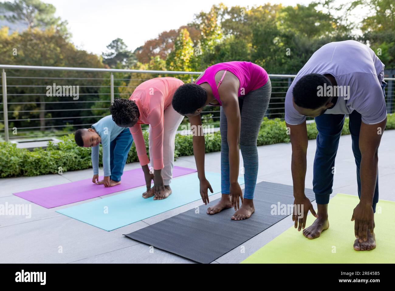 African american couple with son and daughter practicing yoga on sunny ...