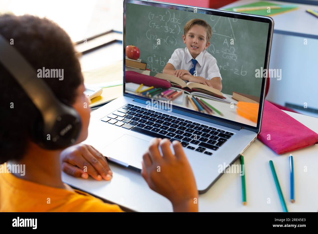 Rear view of a biracial boy having a video call with caucasian boy on ...
