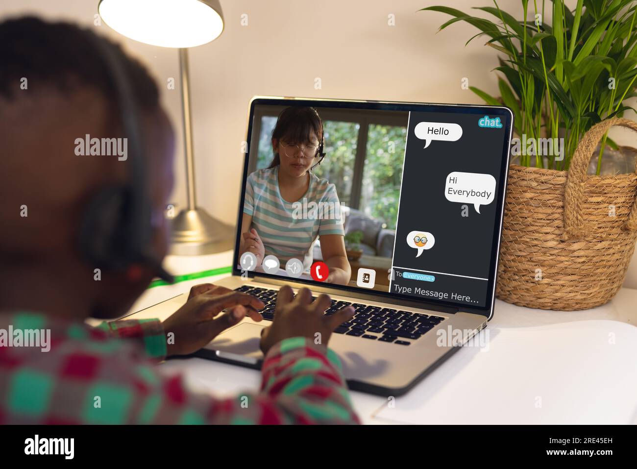Rear view of african american boy having a video call and texting a ...