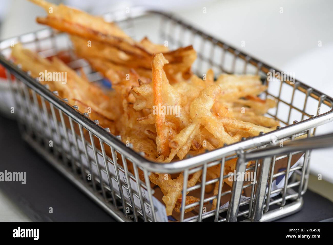 Vegetable tempura served in a frying grate. Taro and carrot tempura ...