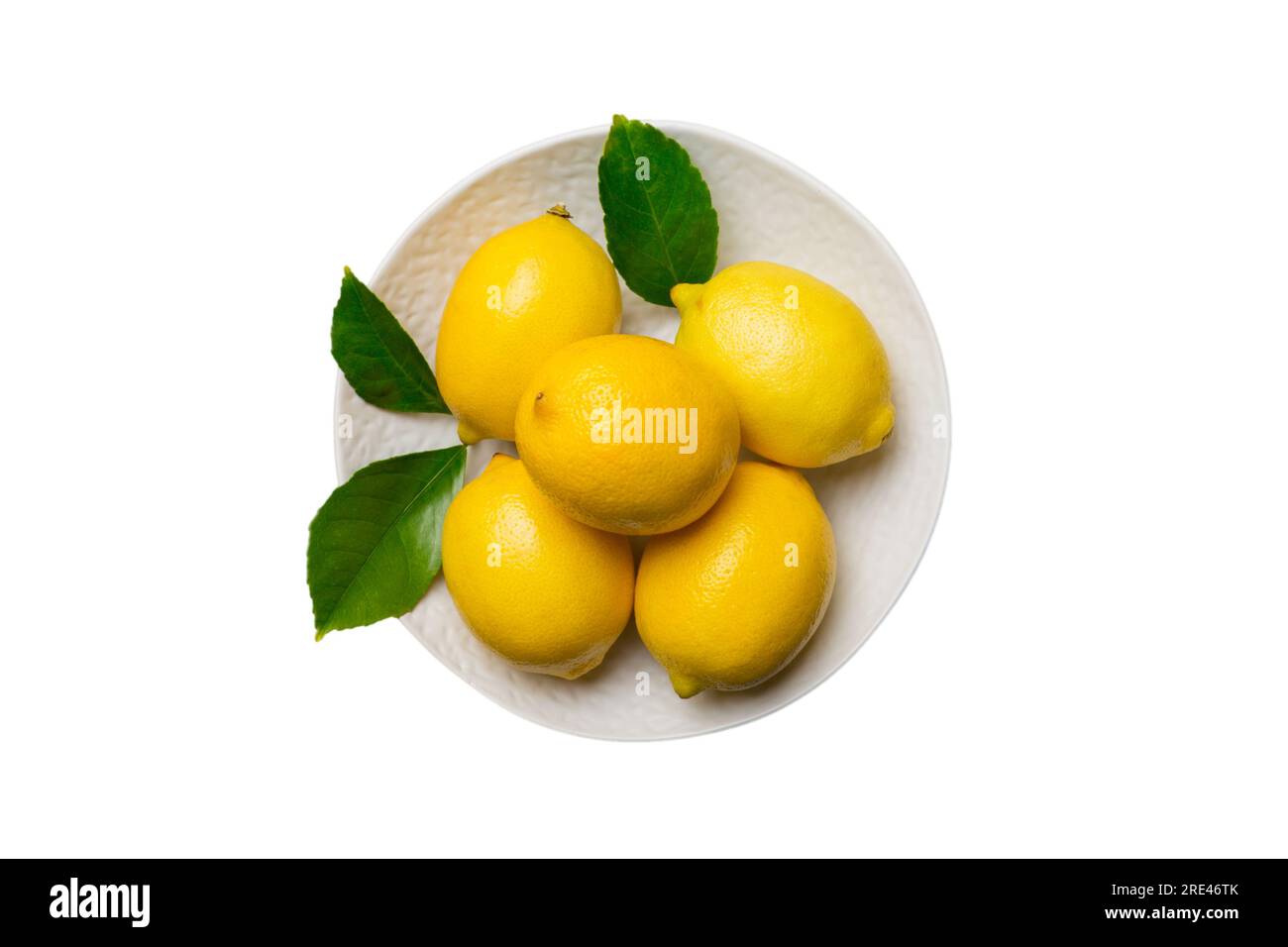 Fresh cutted lemon and whole lemons over round plate isolated on white ...