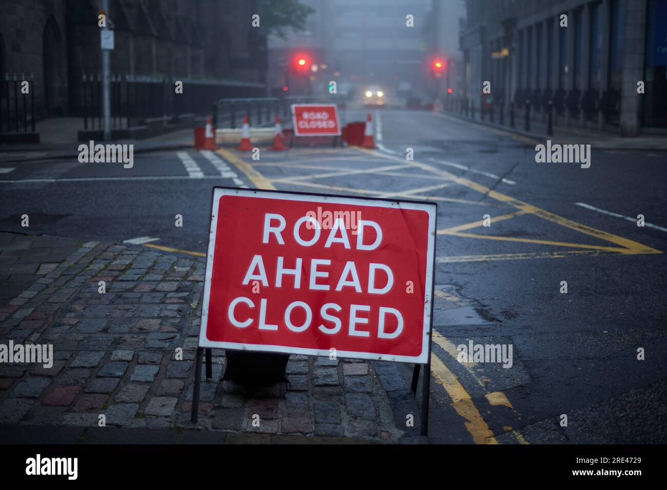 Road ahead closed sign in empty city in the evening Stock Photo - Alamy