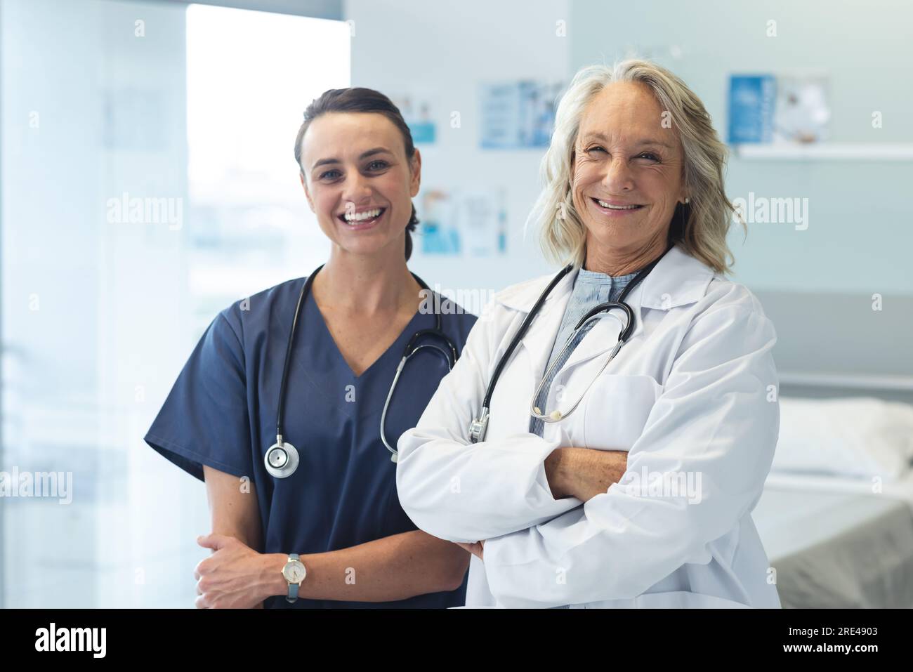 Portrait of happy caucasian female doctors wearing scrubs and lab coat ...