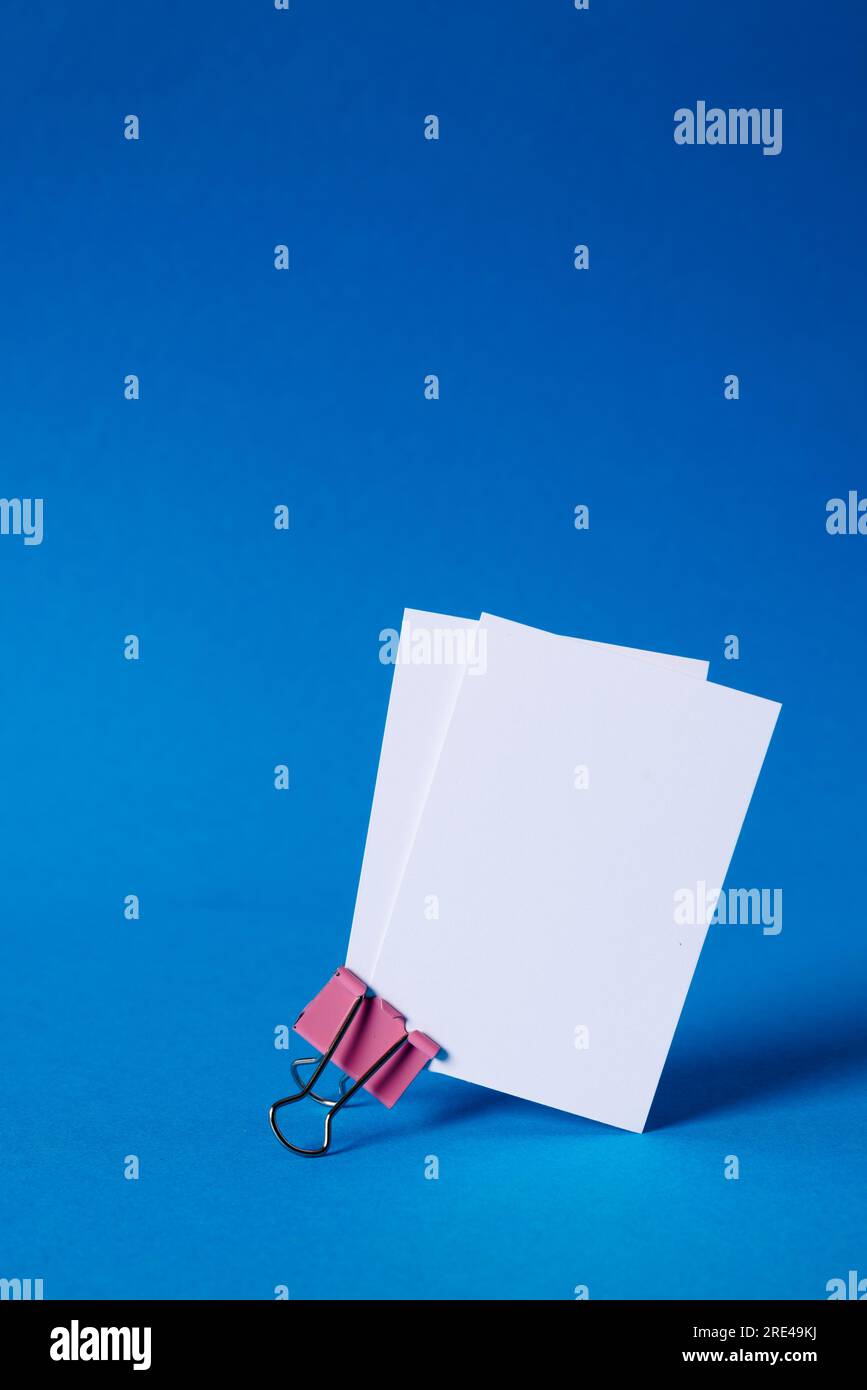 White business cards with paperclip and copy space on blue background ...