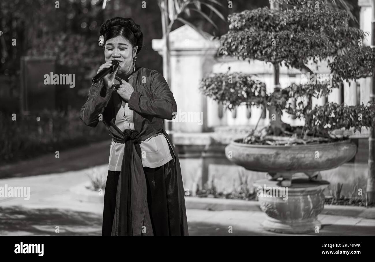 A Vietnamese woman dressed in traditional costume sings Cheo music at ...