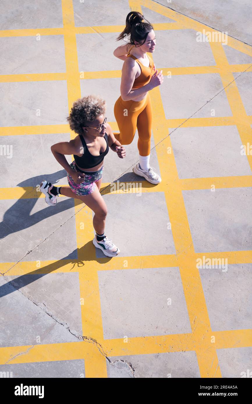 Two women running along road hi-res stock photography and images - Alamy