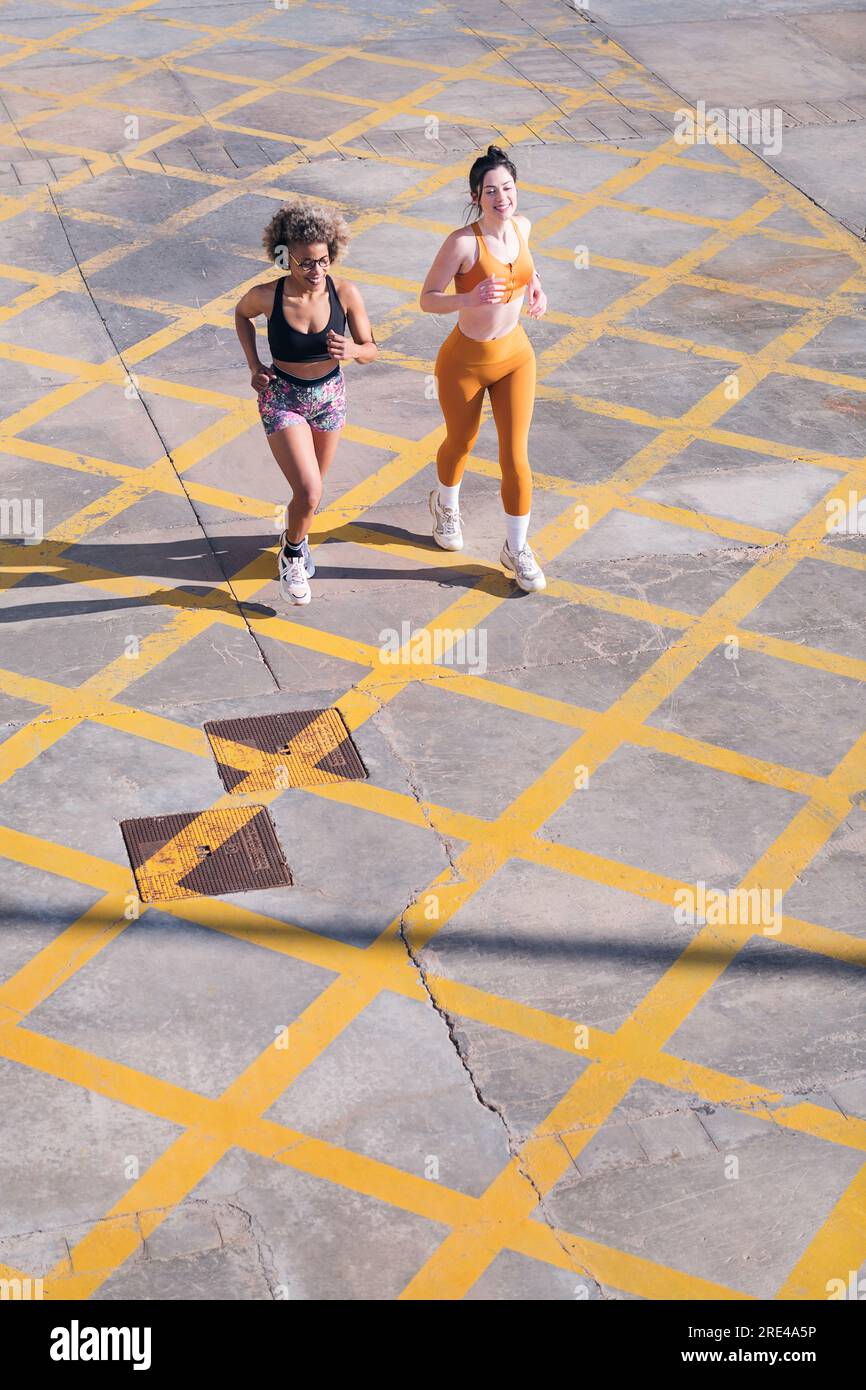 Two women running along road hi-res stock photography and images - Alamy