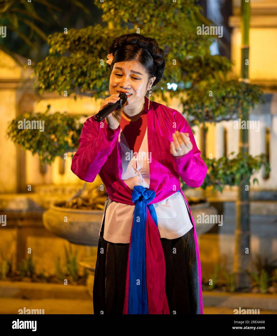 A Vietnamese woman dressed in traditional costume sings Cheo music at ...